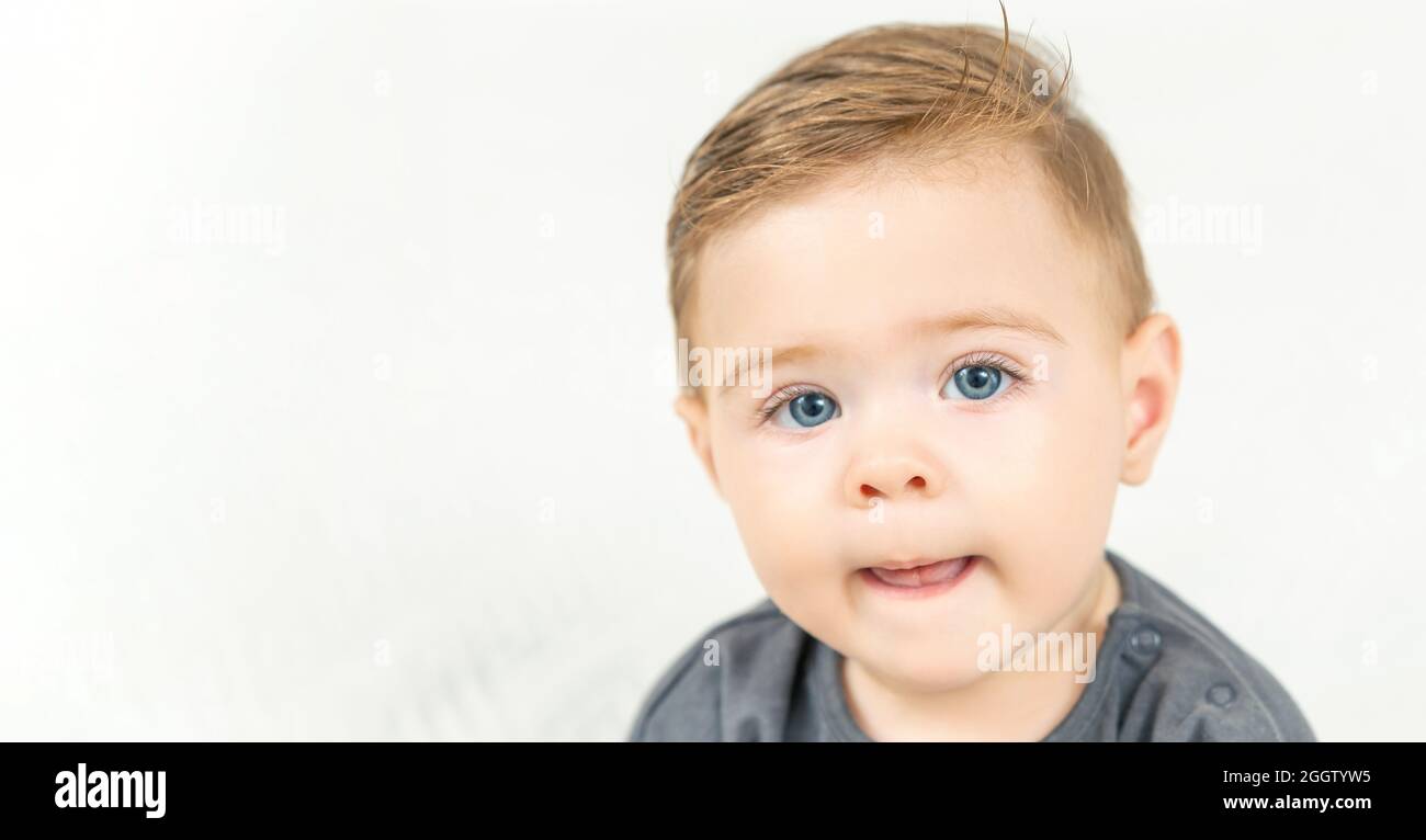 Headshot portrait of adorable smiling baby boy, shows tongue. Copy ...