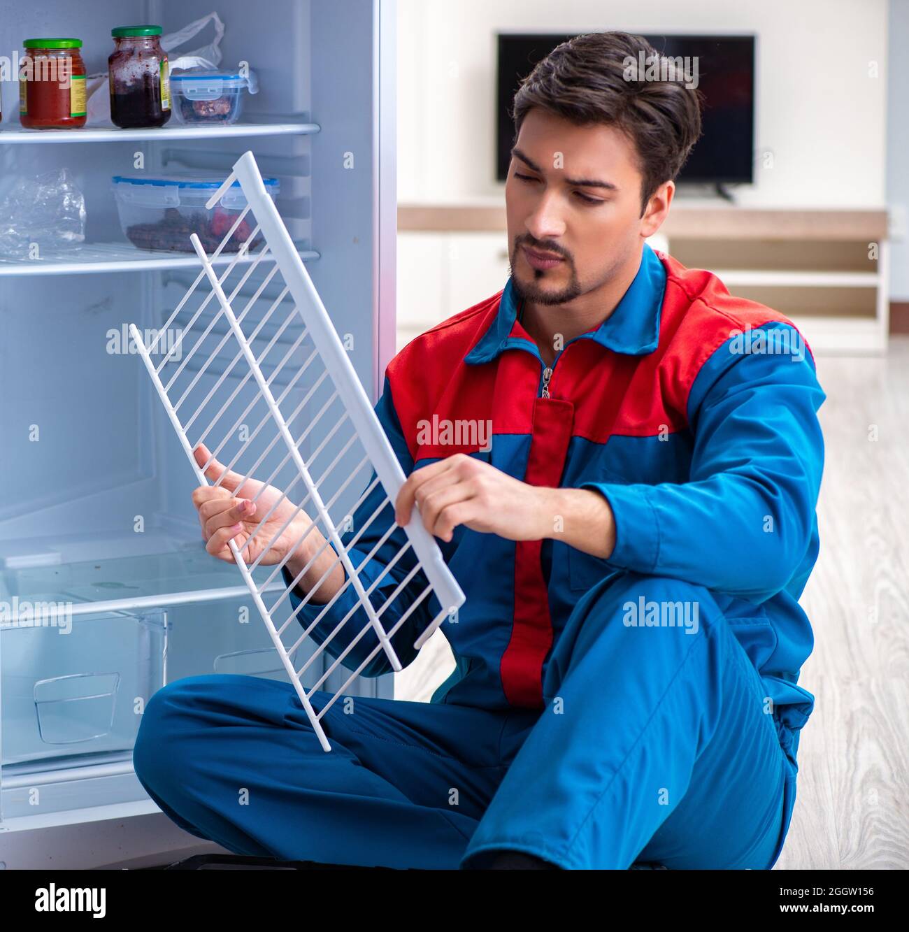 The professional contractor repairing broken fridge Stock Photo - Alamy