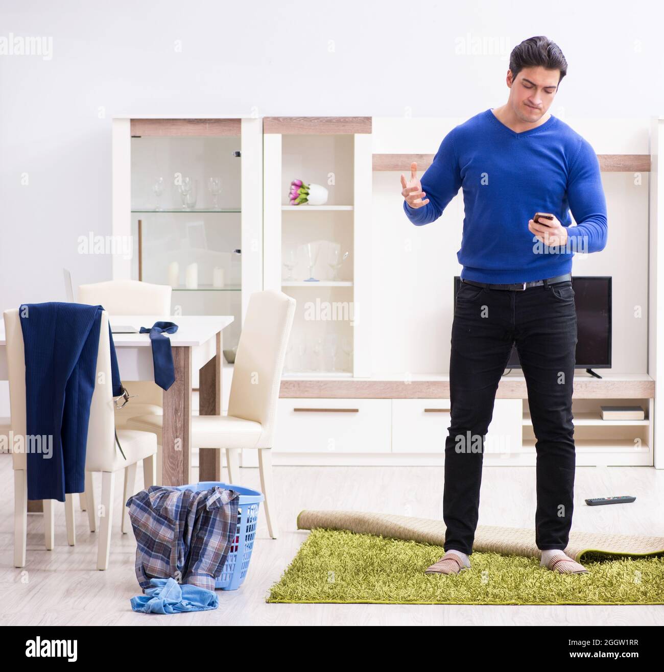 The young man collecting dirty clothing for laundry Stock Photo - Alamy
