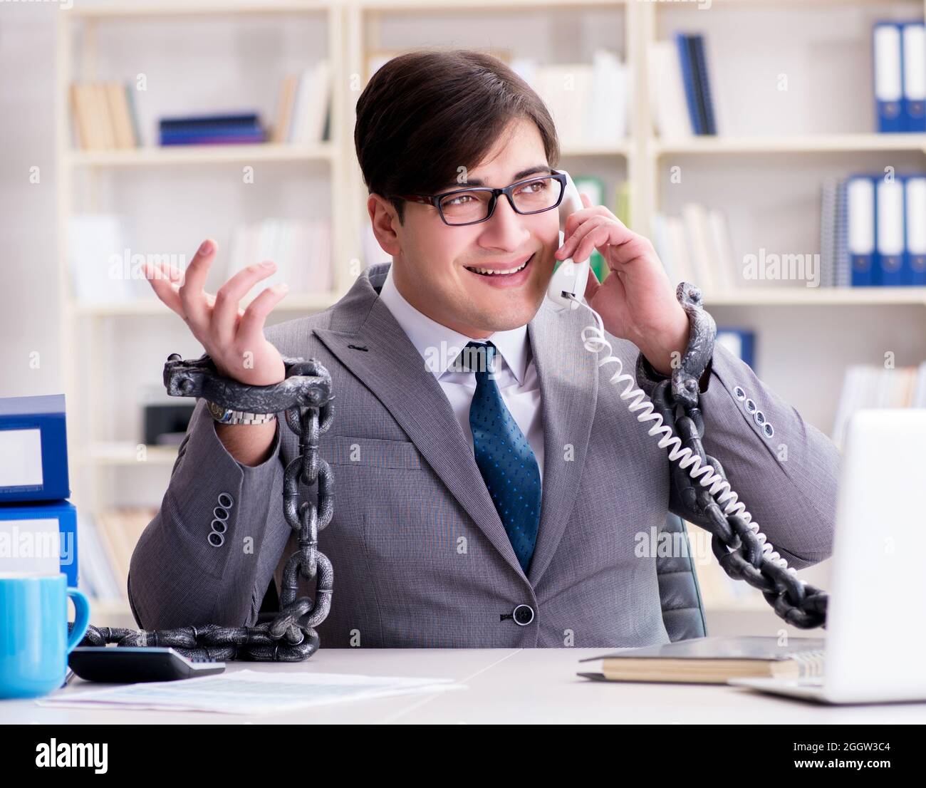 The businessman tied with chains to his work Stock Photo - Alamy