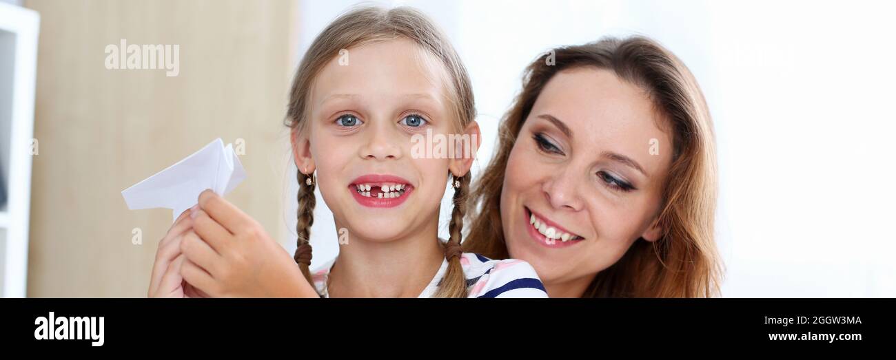 Blond smiling little girl make paper plane Stock Photo - Alamy