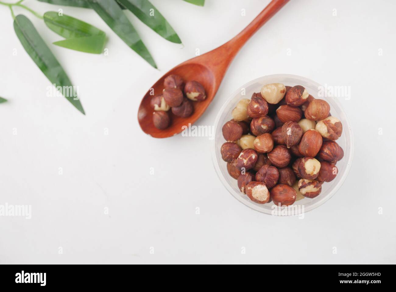hazelnuts in a container on white background Stock Photo - Alamy