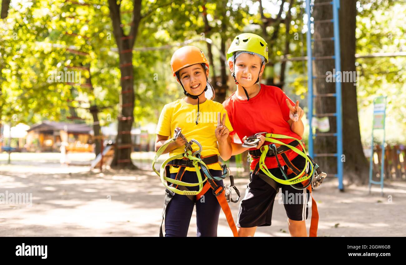 Child in forest adventure park. Kids climb on high rope trail. Agility ...