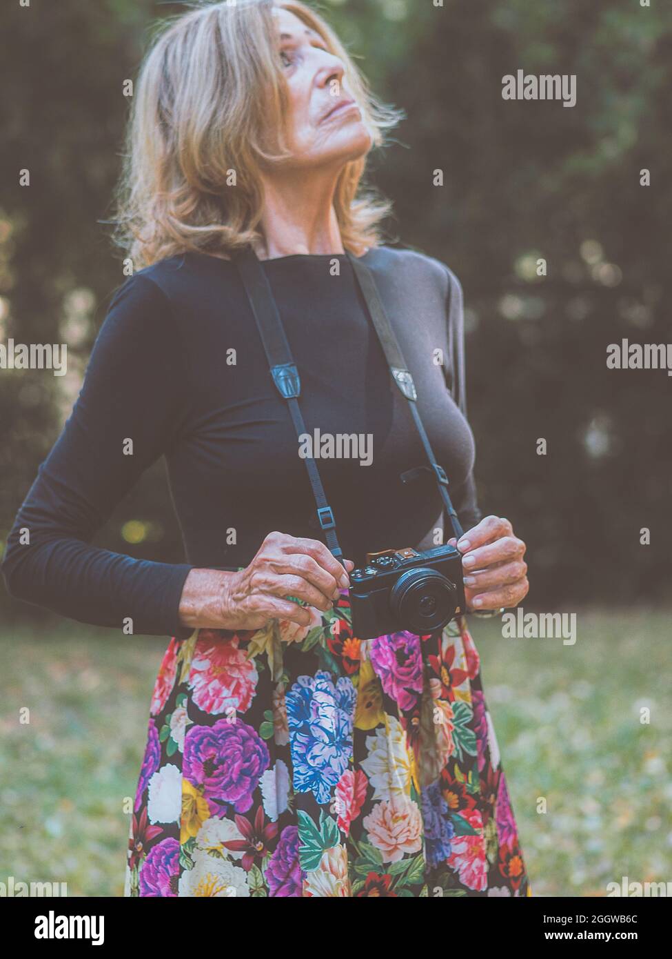 Vertical of a white Caucasian woman wearing a camera around her neck ...
