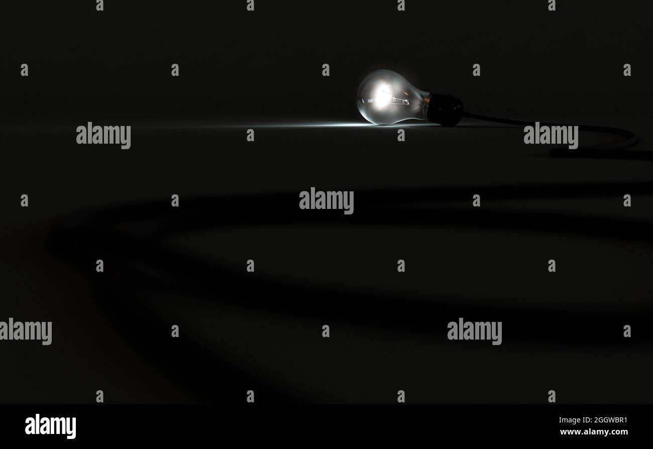 A concept of a draped light cord with a standard light bulb brightly ...