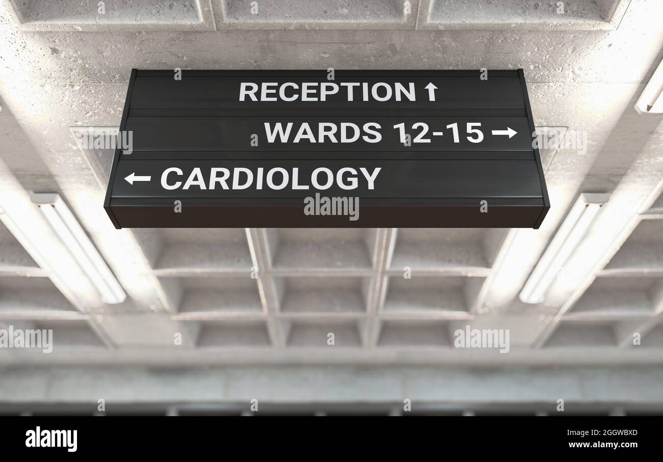 A hospital directional sign mounted on a cast concrete ceiling ...