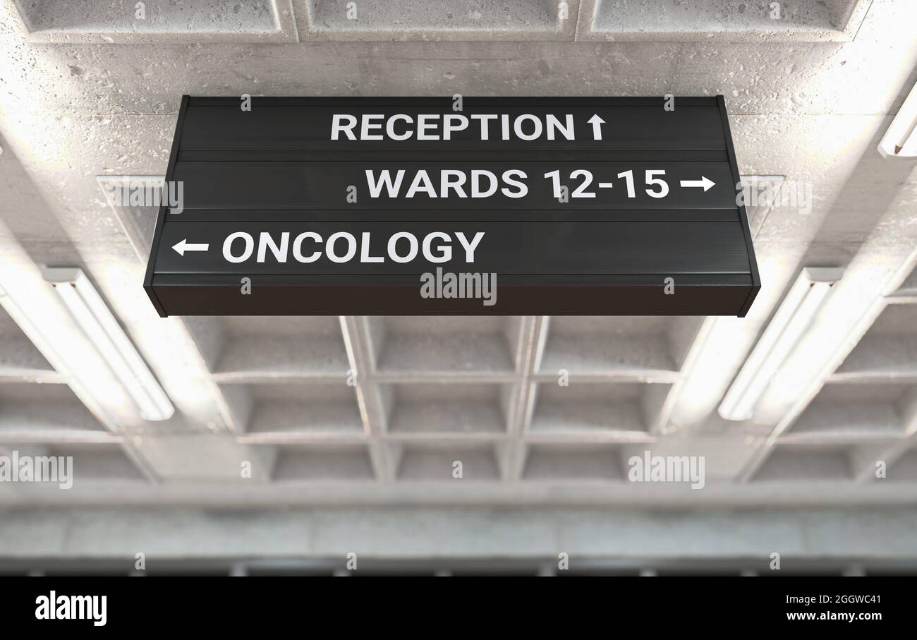 A hospital directional sign mounted on a cast concrete ceiling ...