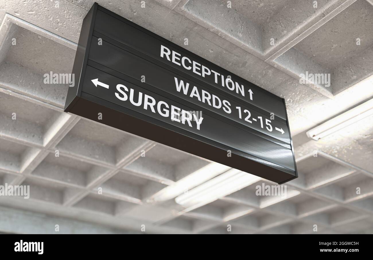 A hospital directional sign mounted on a cast concrete ceiling ...