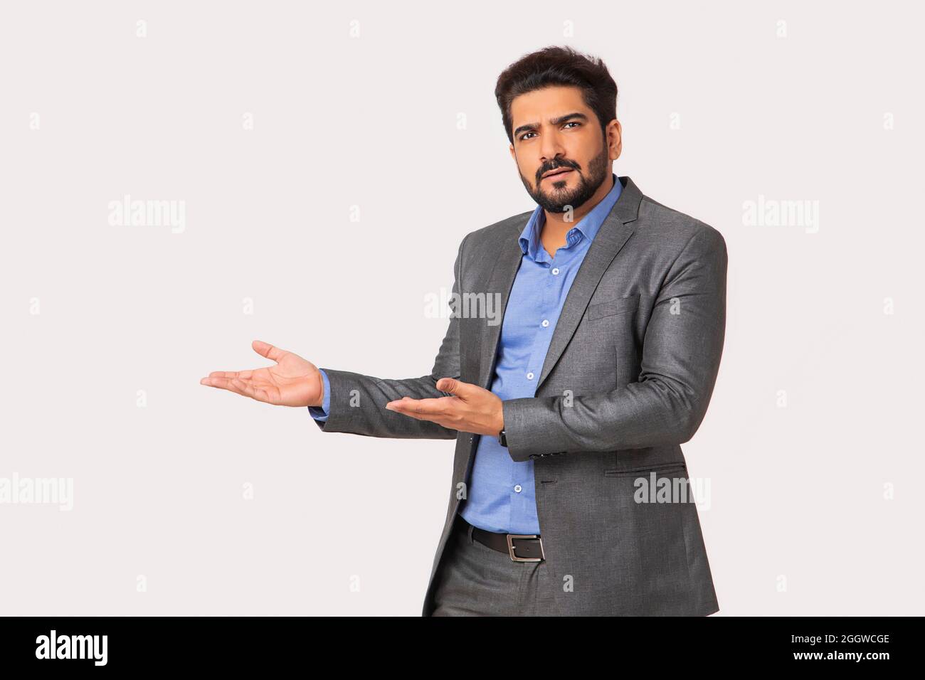 Portrait of a man in formal business suit pointing sideways against ...