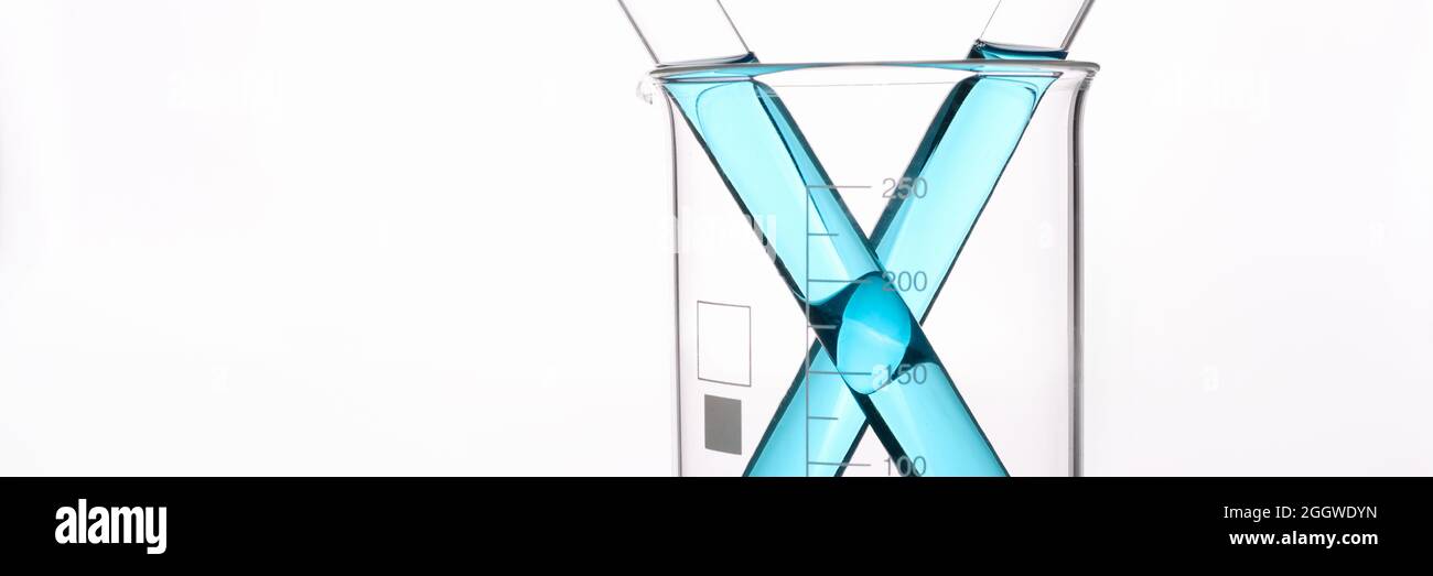 Two test tubes with blue acid standing in glass beaker on white ...