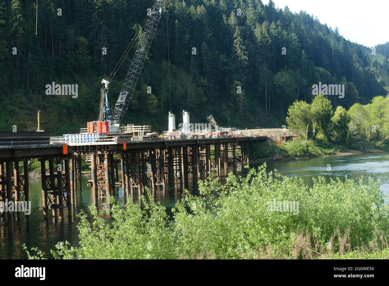 Bridge repairing process on water in Oregon cascades with dense green ...