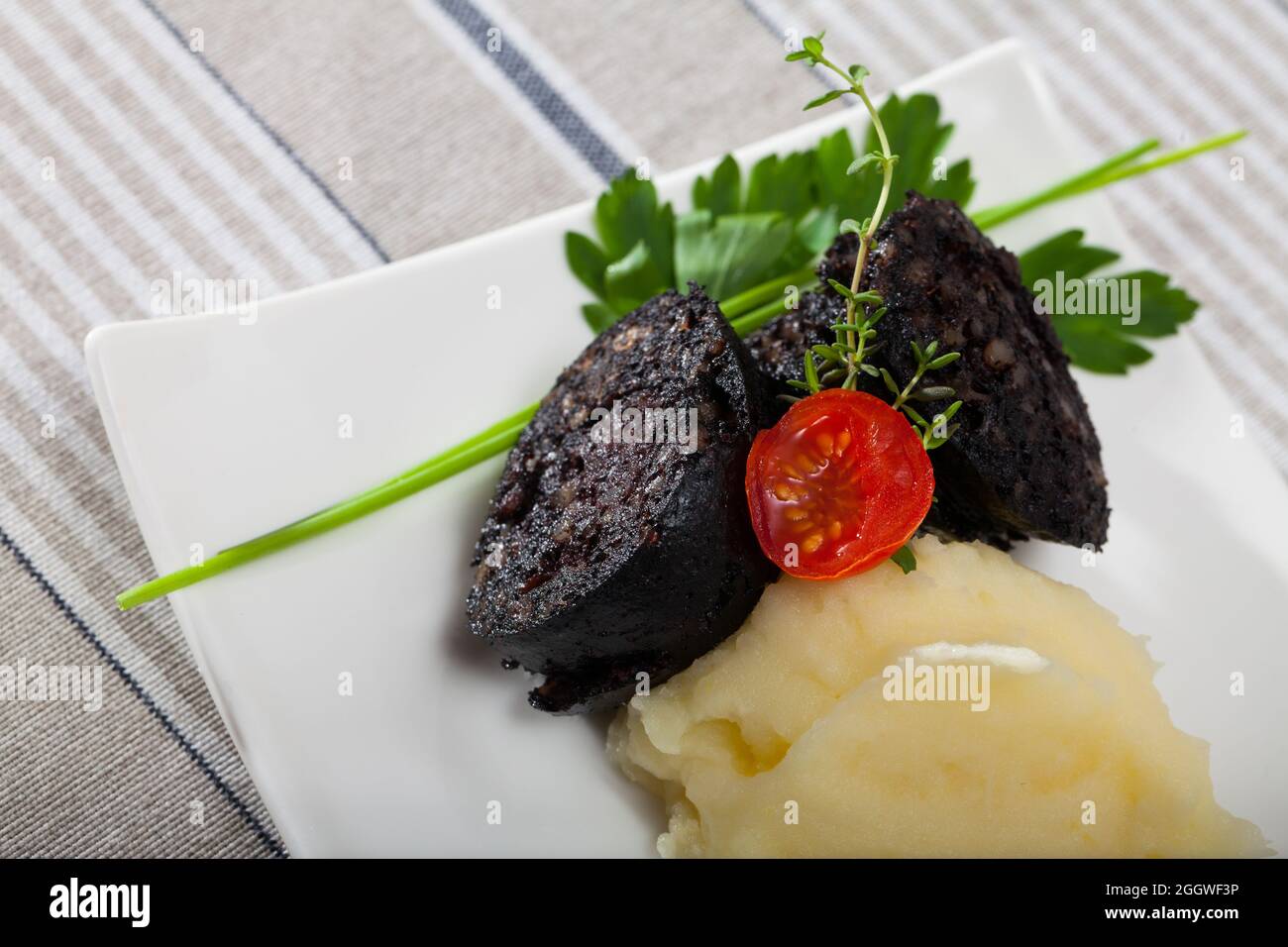 Blood sausage with mashed potato served at plate with greens Stock ...