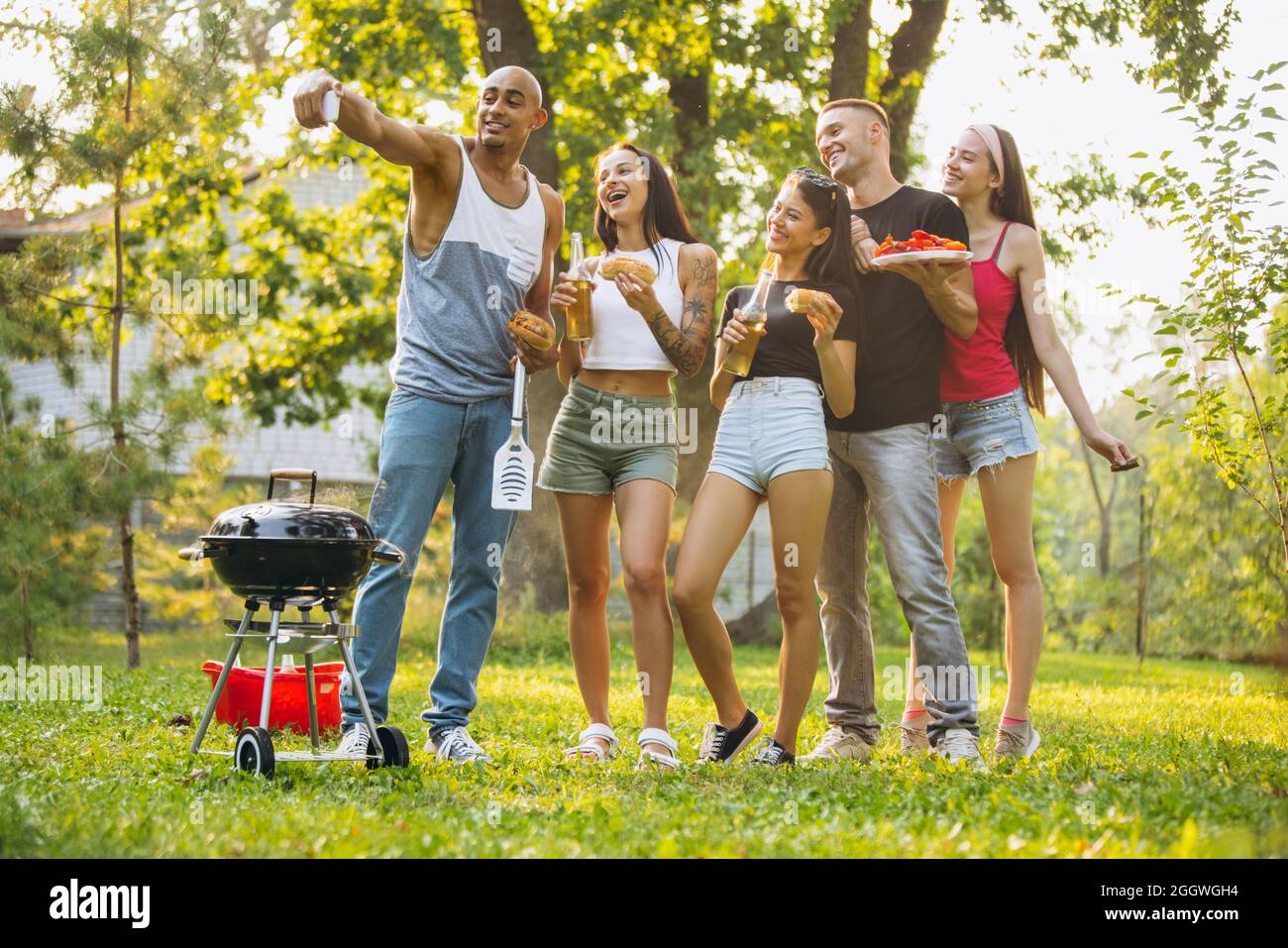 Full-length portrait of five friends spending time together outside ...
