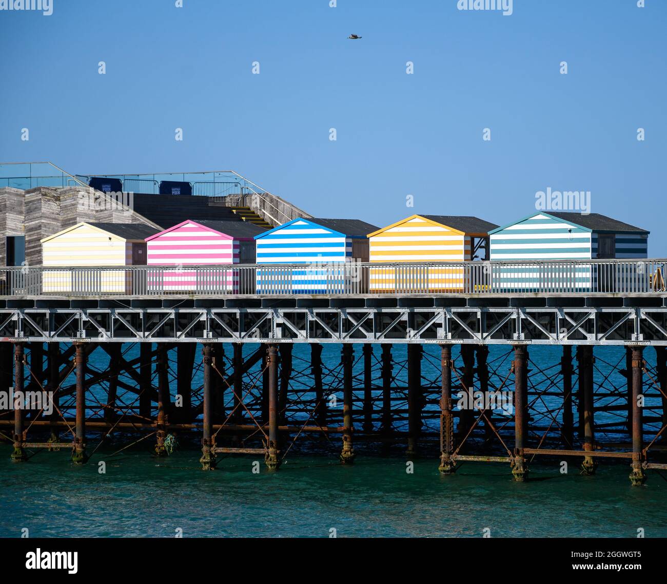 A line of colourful beach huts on Hastings Pier Stock Photo - Alamy