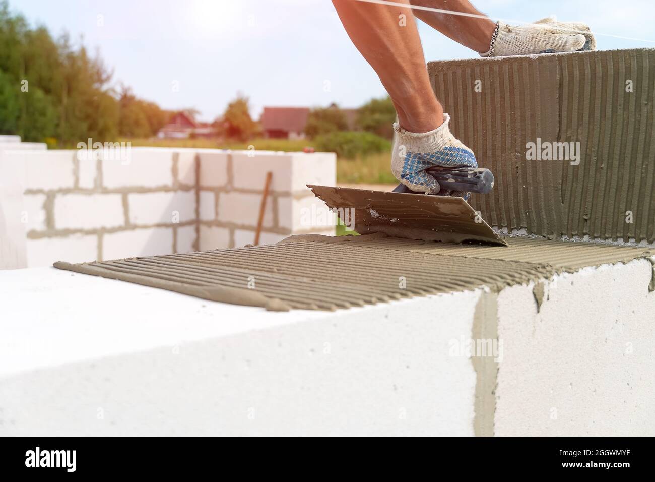 Builder uses a notched trowel to apply the cement mixture to the sides ...