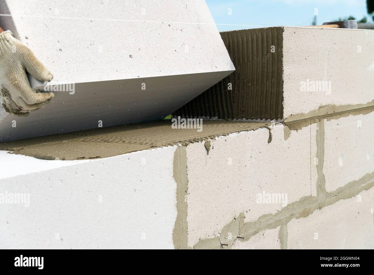Builder makes a concrete wall with cement blocks on the construction ...