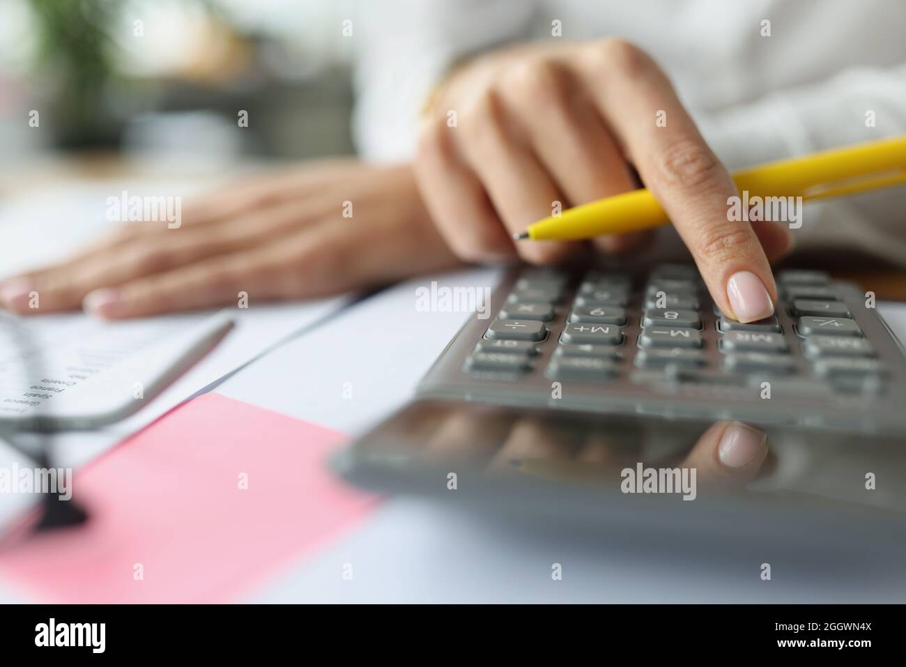 Accountant hand pressing buttons on calculator at table with documents ...