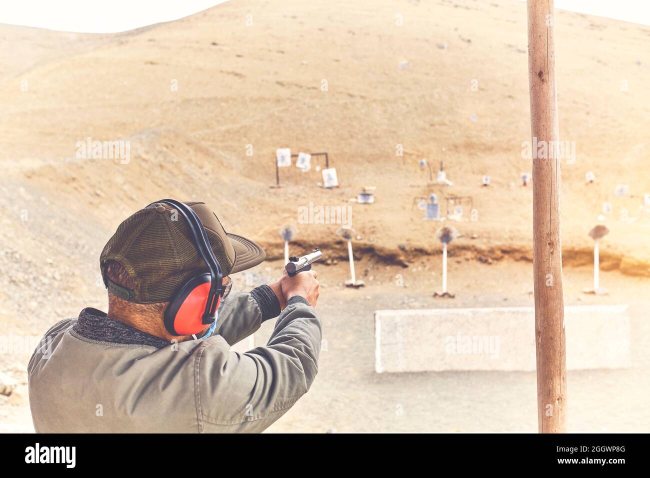 Man with hand gun aiming at shooting range and releasing stress ...