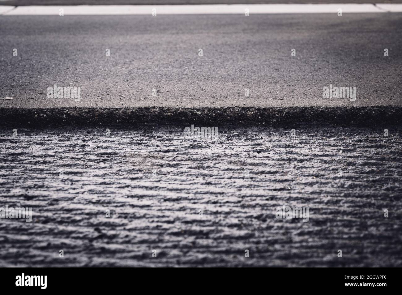 low angle selective focus on asphalt overlay paving on top of a ...