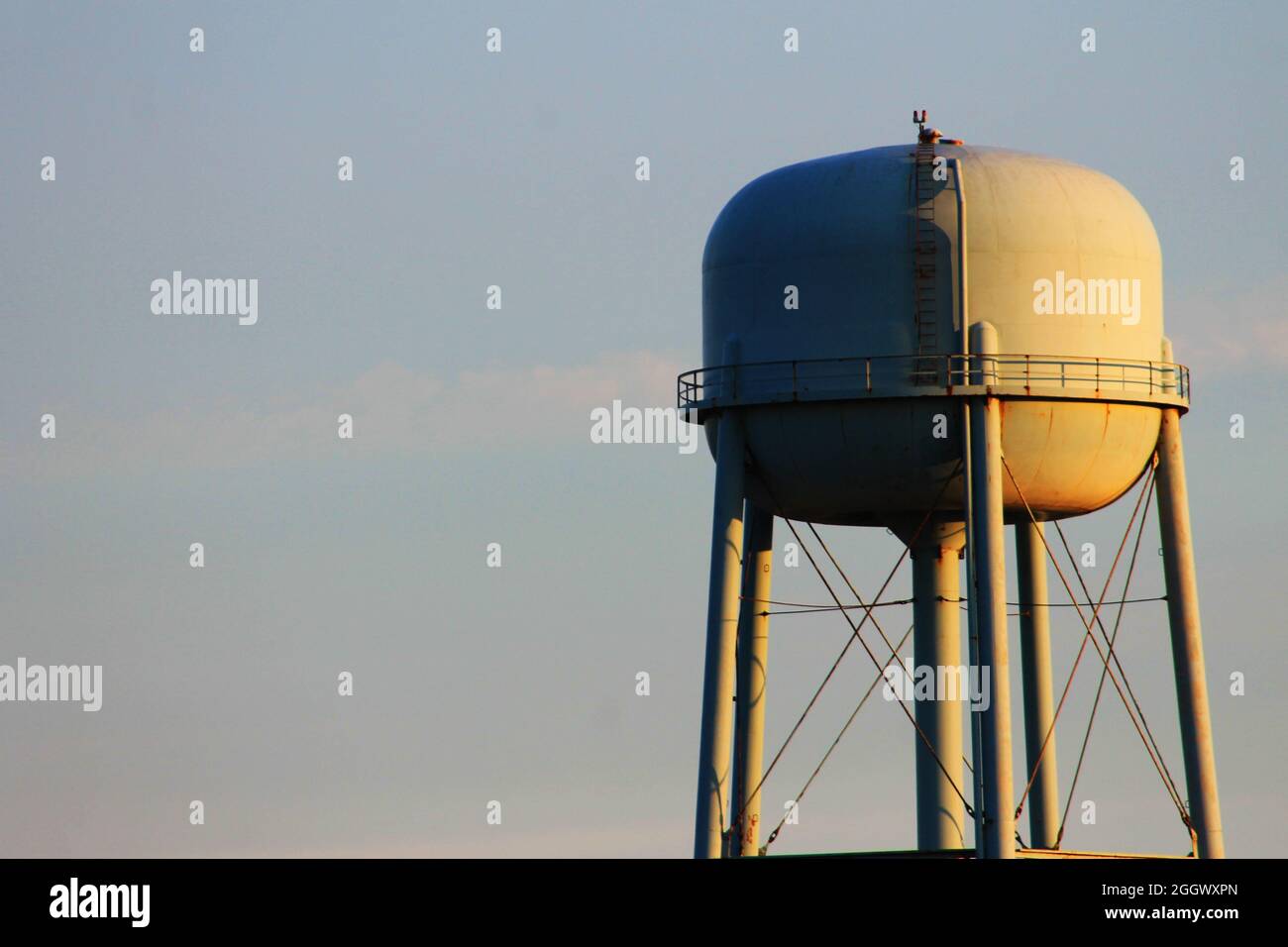 Tank at the top of a steel water tower at sunset Stock Photo - Alamy