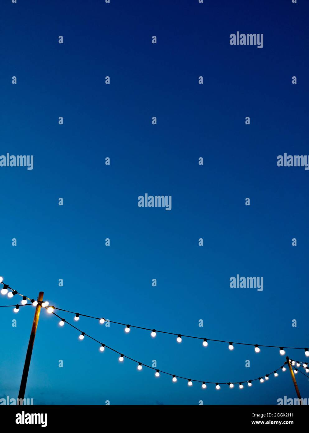 a many light bulb with wire cable in blue sky Stock Photo - Alamy