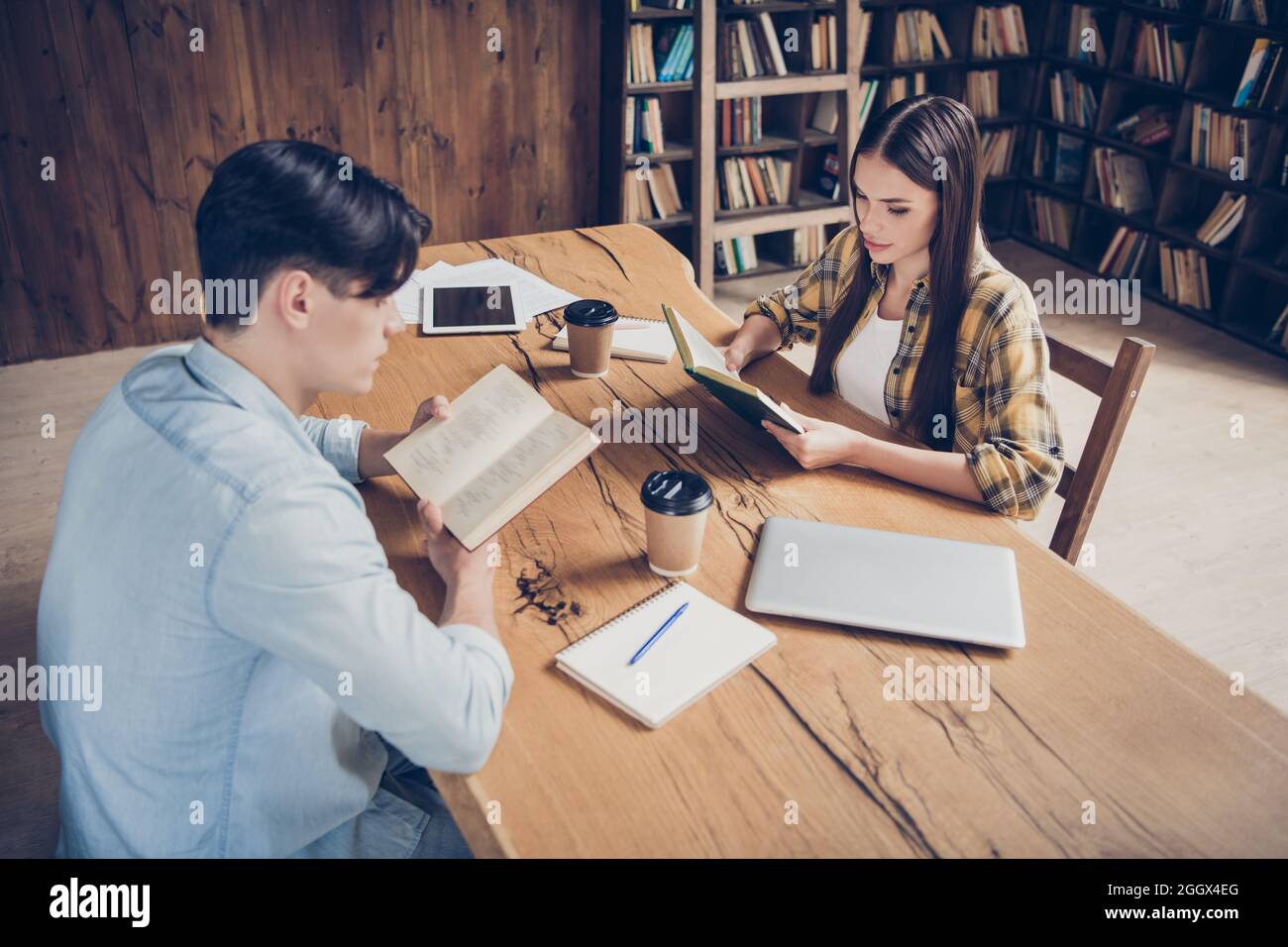 Portrait of two attractive creative focused people doing task reading ...
