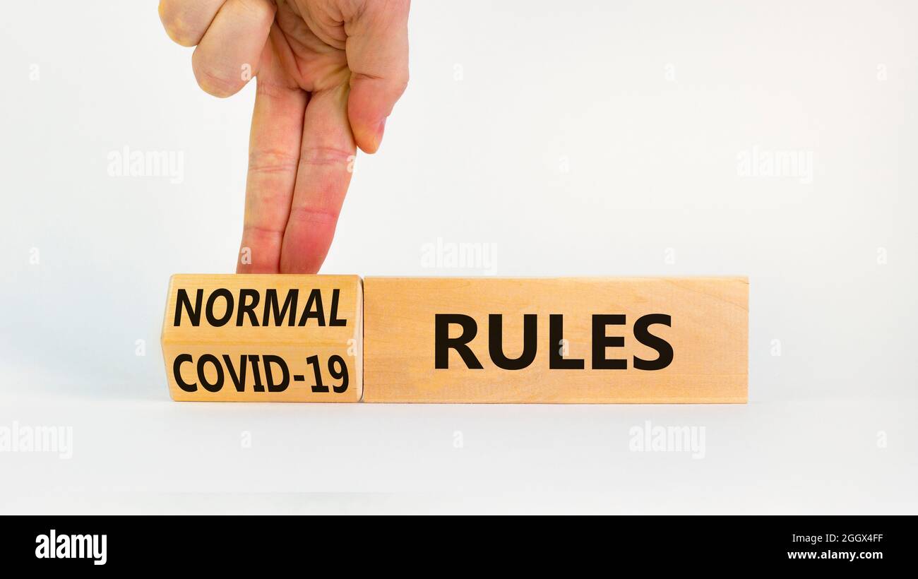 Symbol of covid-19 or normal rules. Doctor turns a wooden cube and ...