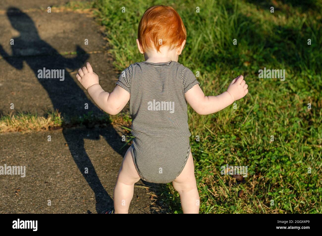 toddler. red hair. walking. shadow Stock Photo - Alamy