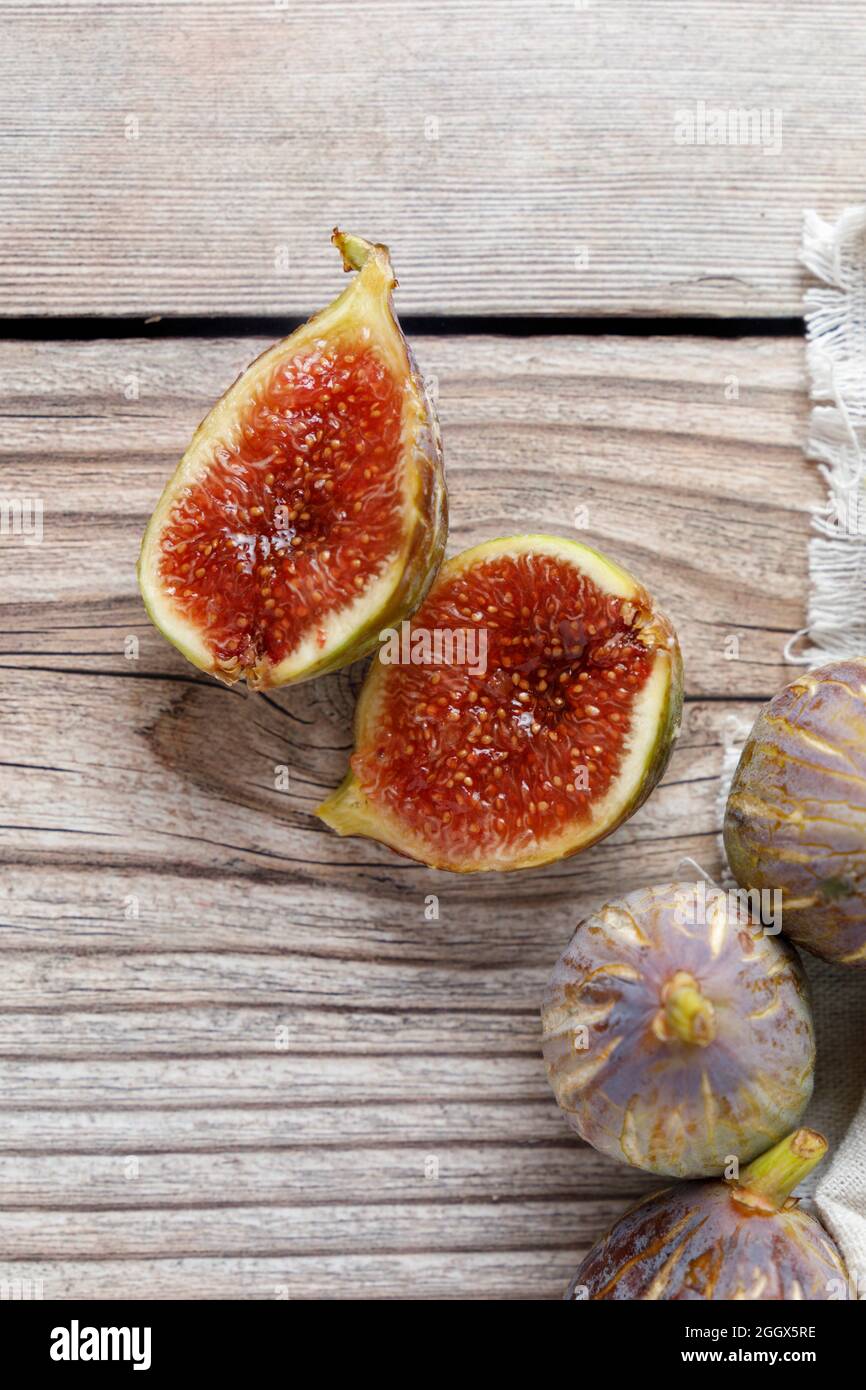 fig open in two parts next to other whole figs on wooden table Stock ...
