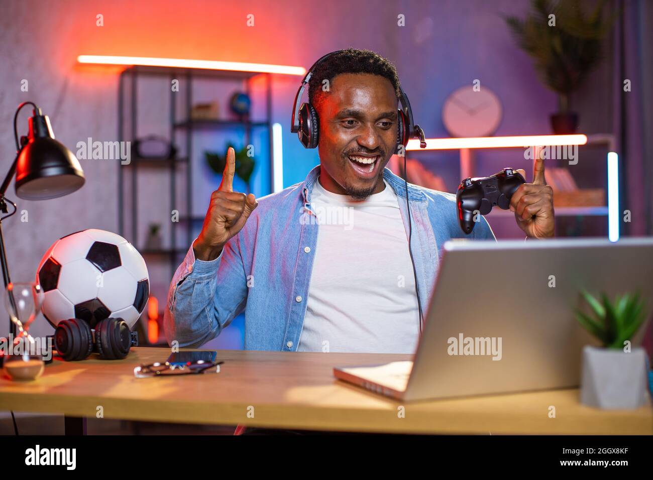 Emotional black man in headset looking at computer screen and feeling ...