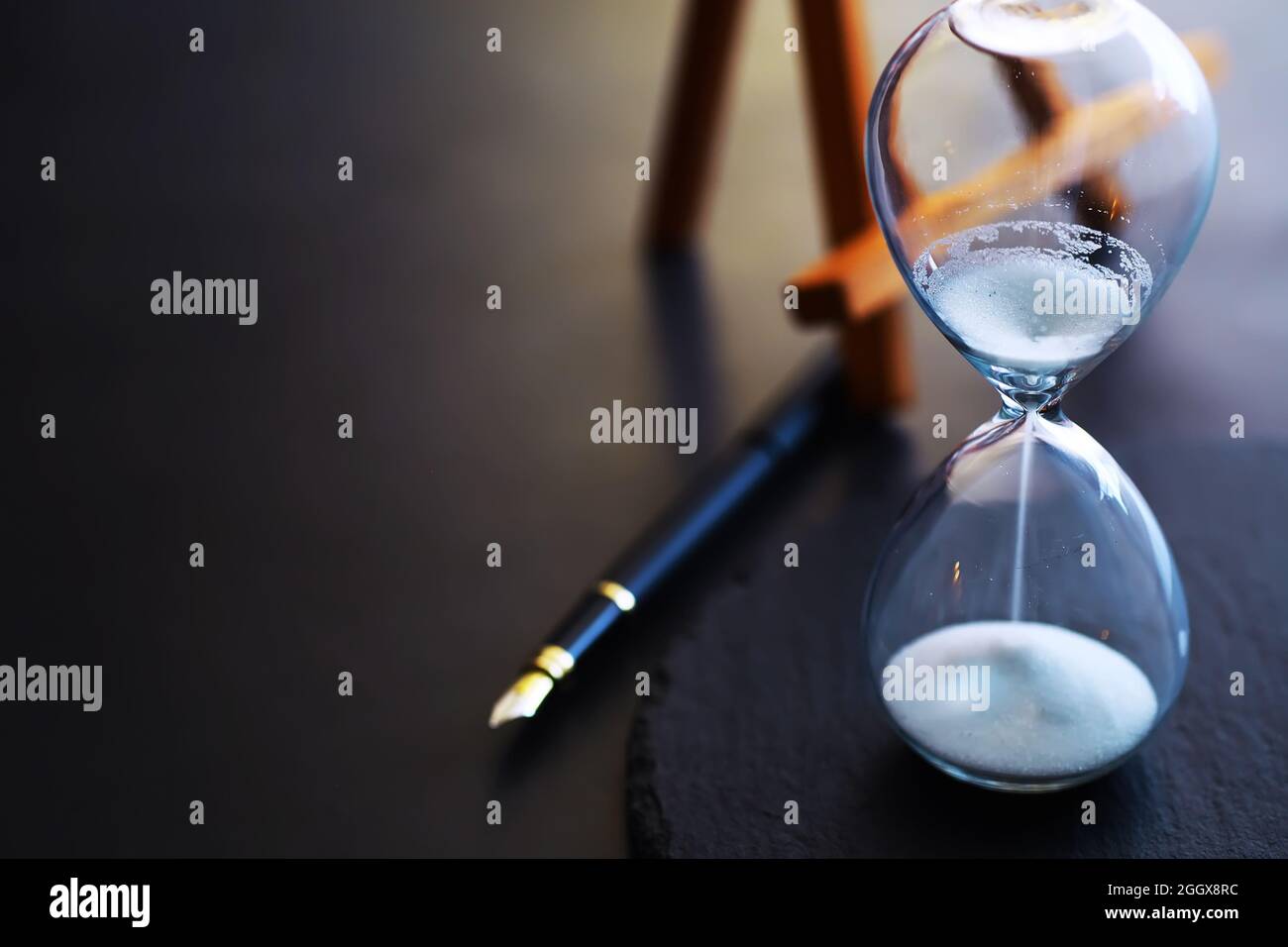 Sand running through the bulbs of an hourglass measuring the passing ...