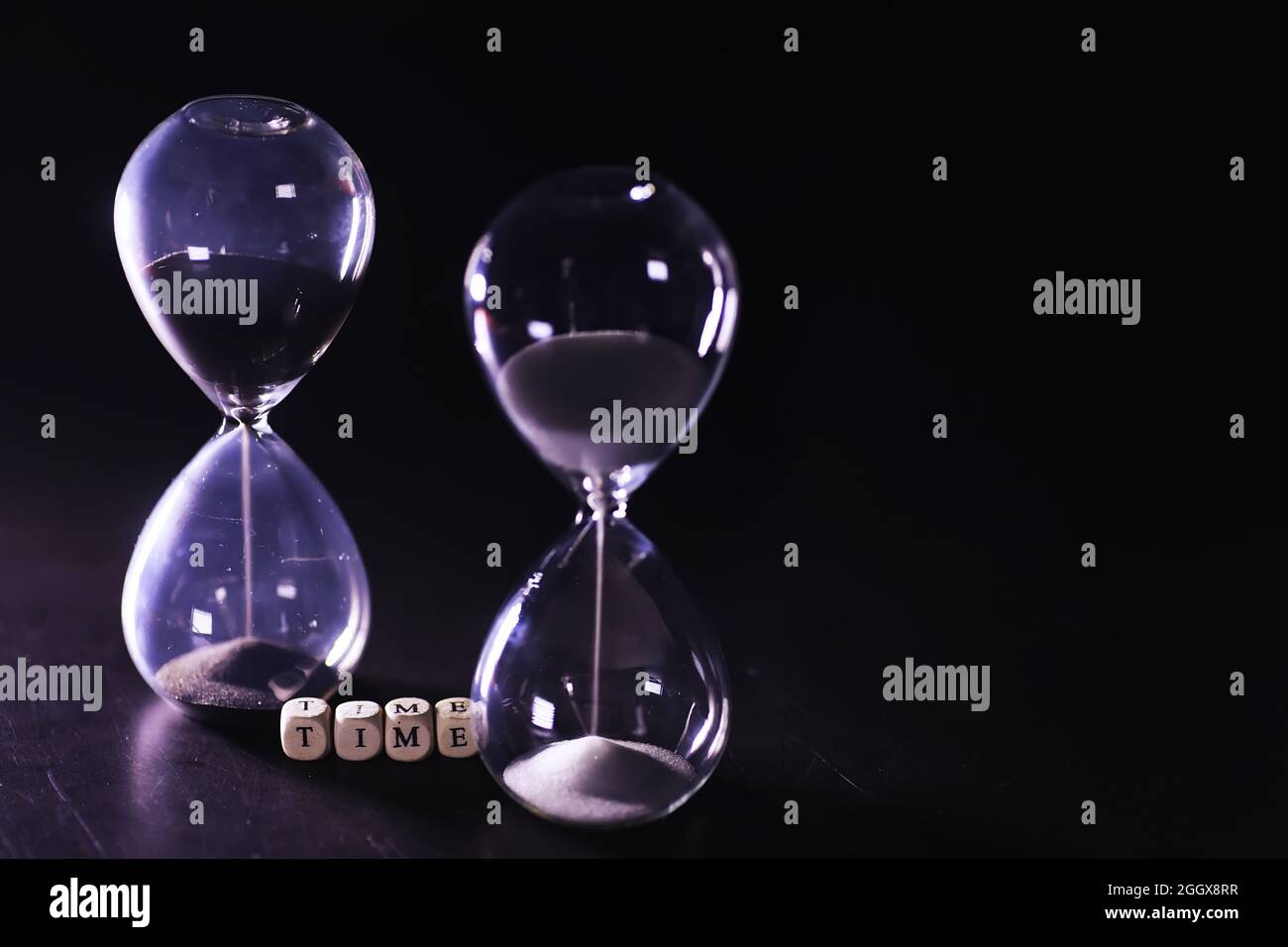 Sand running through the bulbs of an hourglass measuring the passing ...