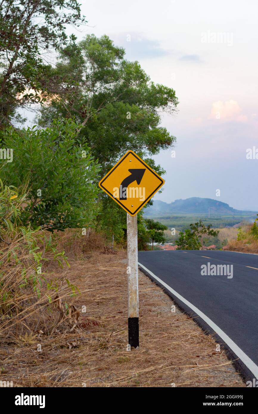 curvy road sign beside country road to the middle of city, Concept of ...