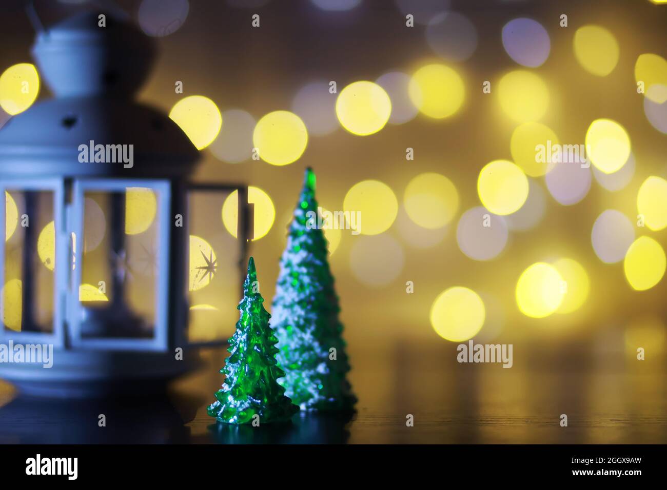 Red Christmas tree toy on a branch of a natural fir tree with lights of ...