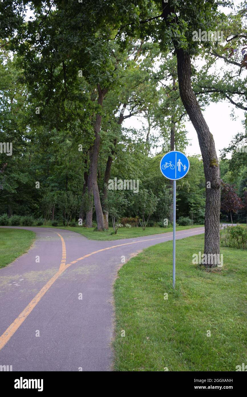 An empty path in a summer park for bicycles and pedestrians, which ...