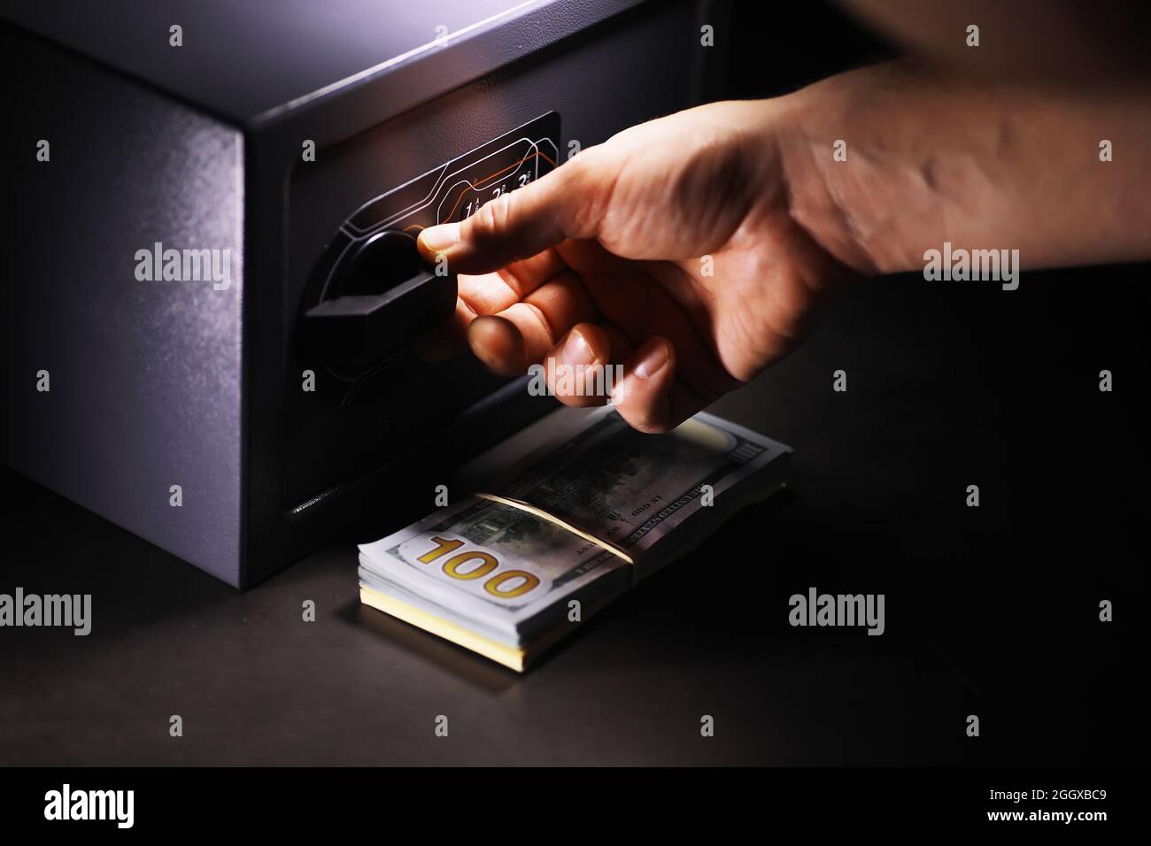 Steel safe with money. Hand putting password in the safety money box in ...