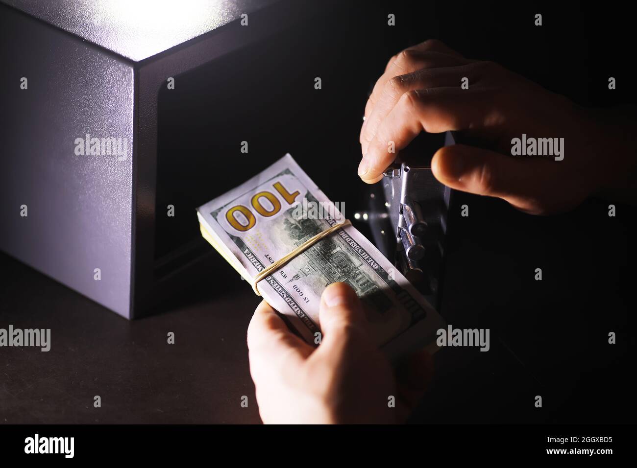 Steel safe with money. Hand putting password in the safety money box in ...