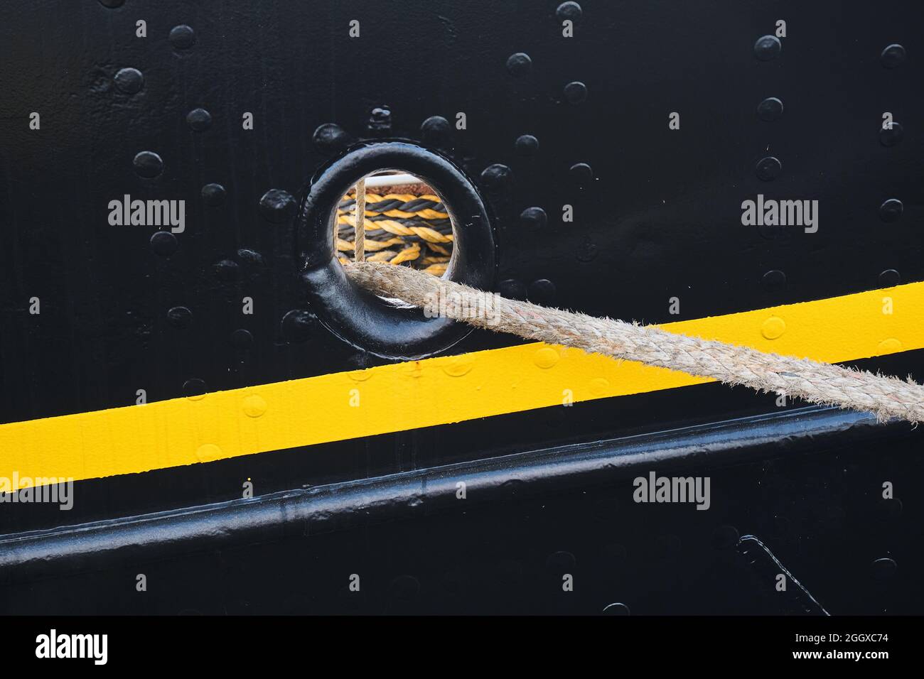 Hatch for a mooring line, black ship with yellow line Stock Photo - Alamy