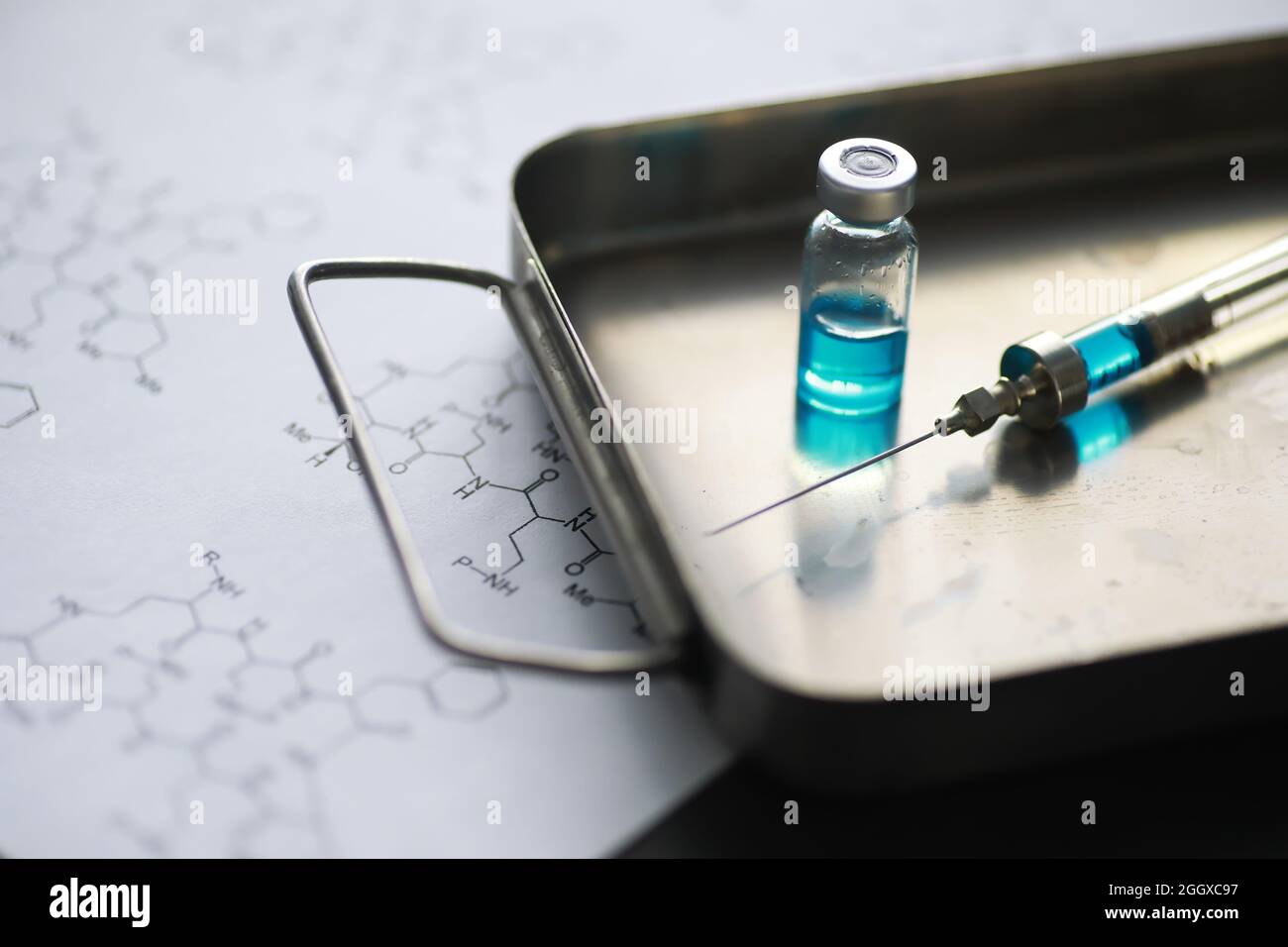 small jars with injection and syringe for injection on blue background ...