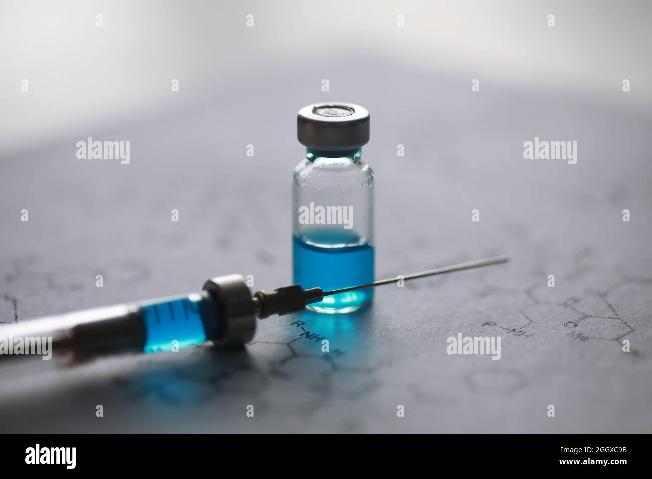 small jars with injection and syringe for injection on blue background ...