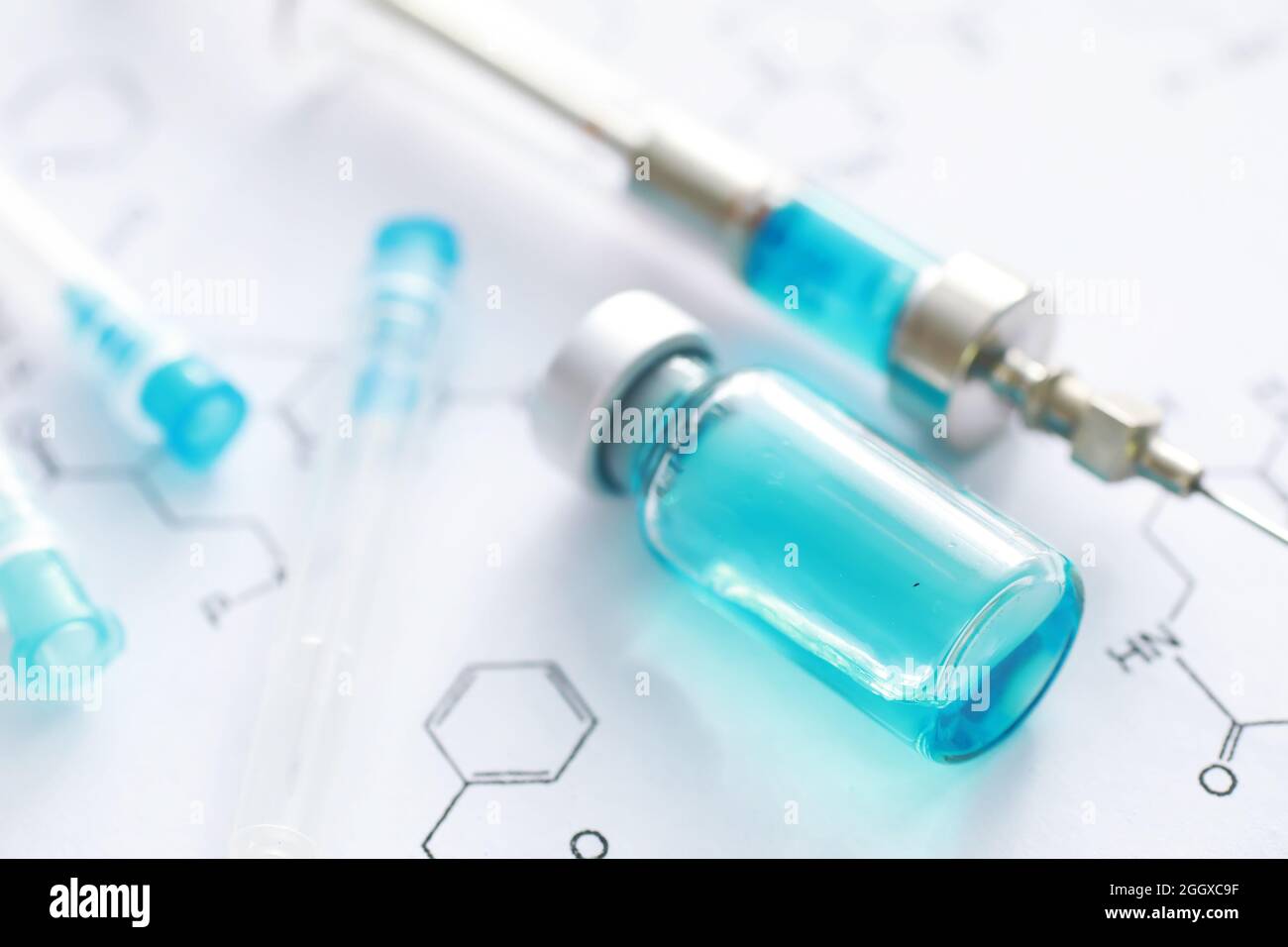 small jars with injection and syringe for injection on blue background ...