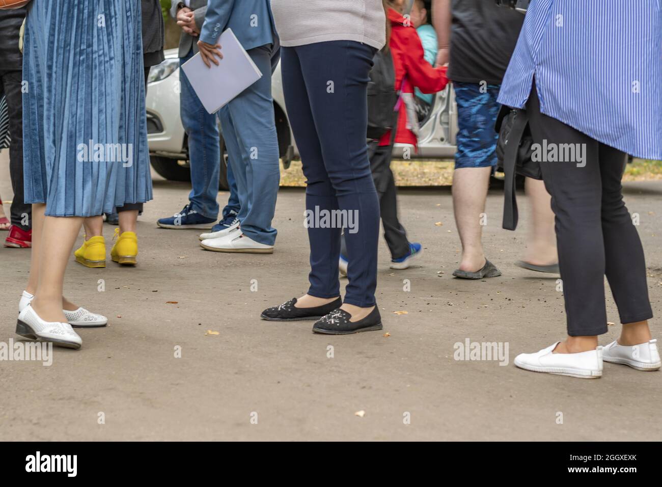 A group of people stand on a city street and communicate with each ...