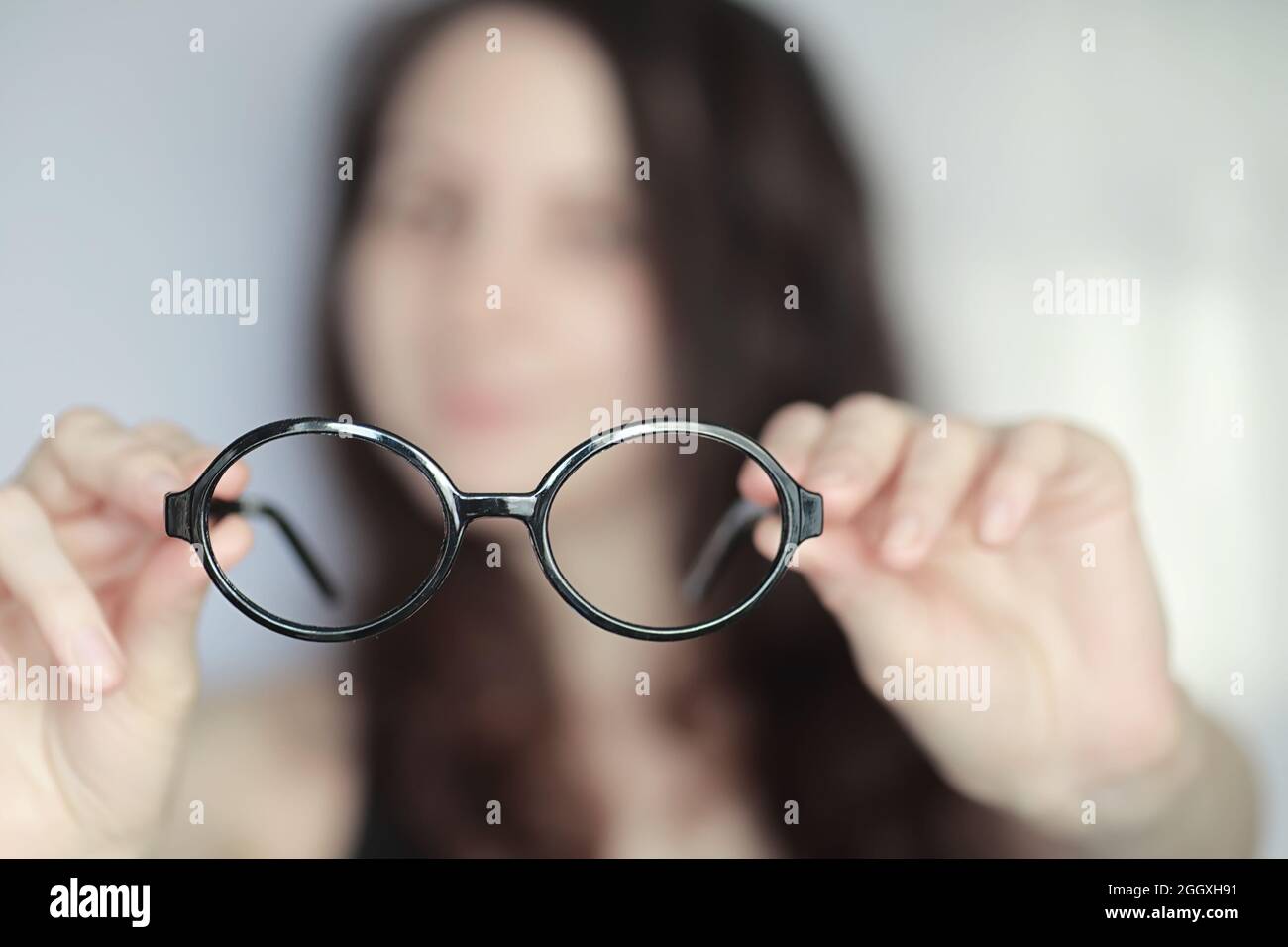 The concept of poor vision. Hold a contact lens and glasses in hand ...