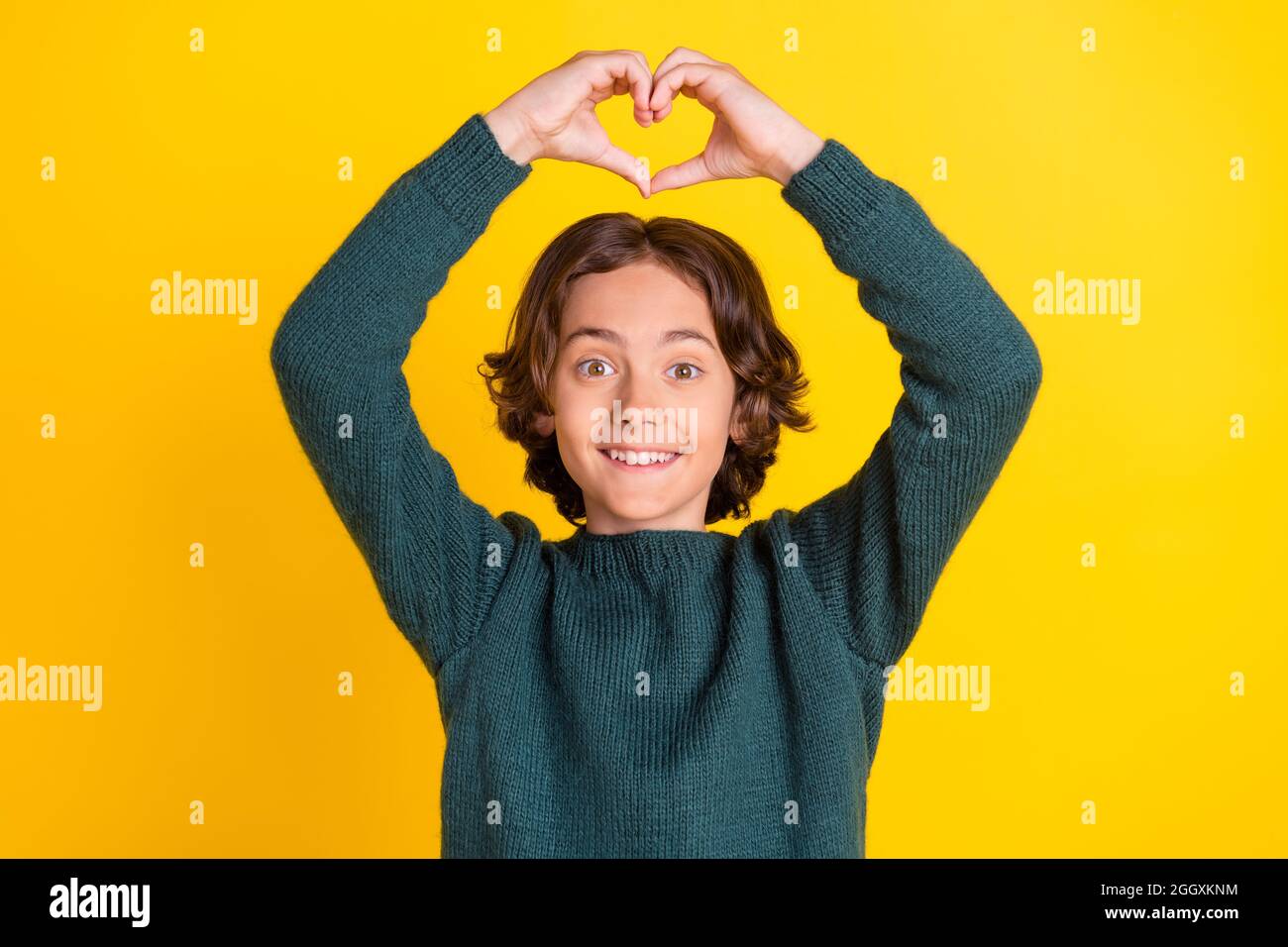 Portrait of attractive cheerful boy showing heart sign health care ...