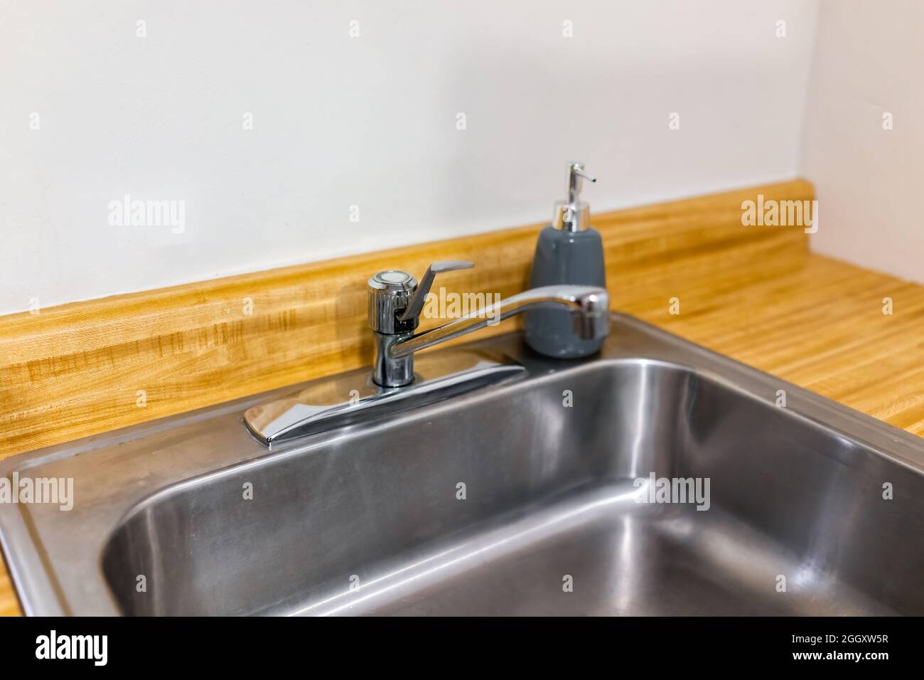 New modern faucet and kitchen room stainless steel sink closeup with ...