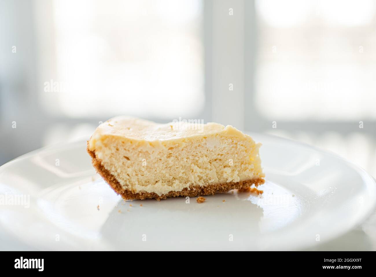 One piece slice of plain cheese cake cheesecake on plate at home or ...