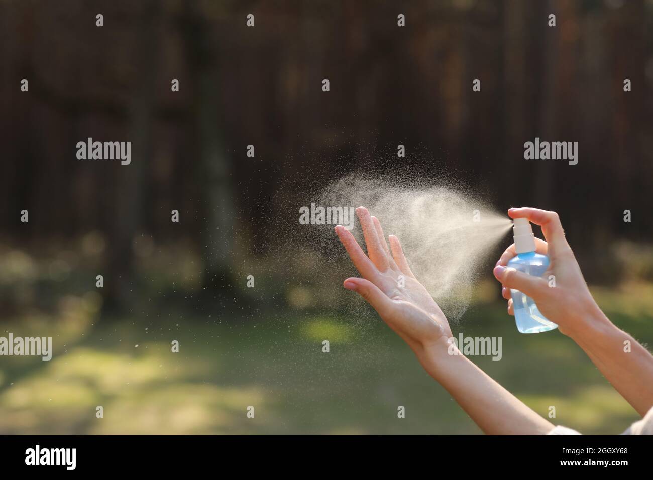 Womans hand pressing Alcohol Spray in the nature for clean her hand ...