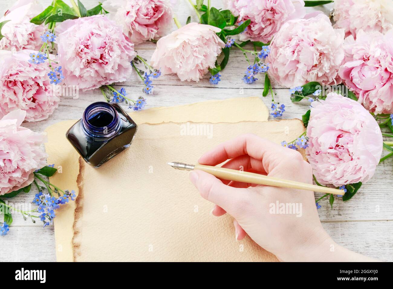Vintage sheet of paper and pen. Pink peonies and forget me not flowers ...