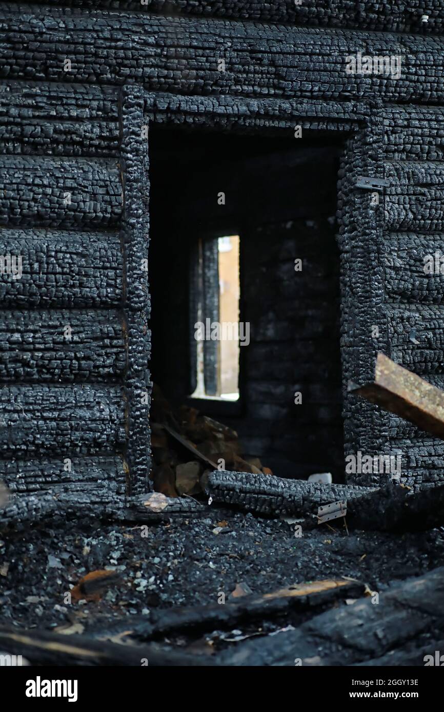 Wooden house after the fire. Coals on the logs. The ashes of the house ...