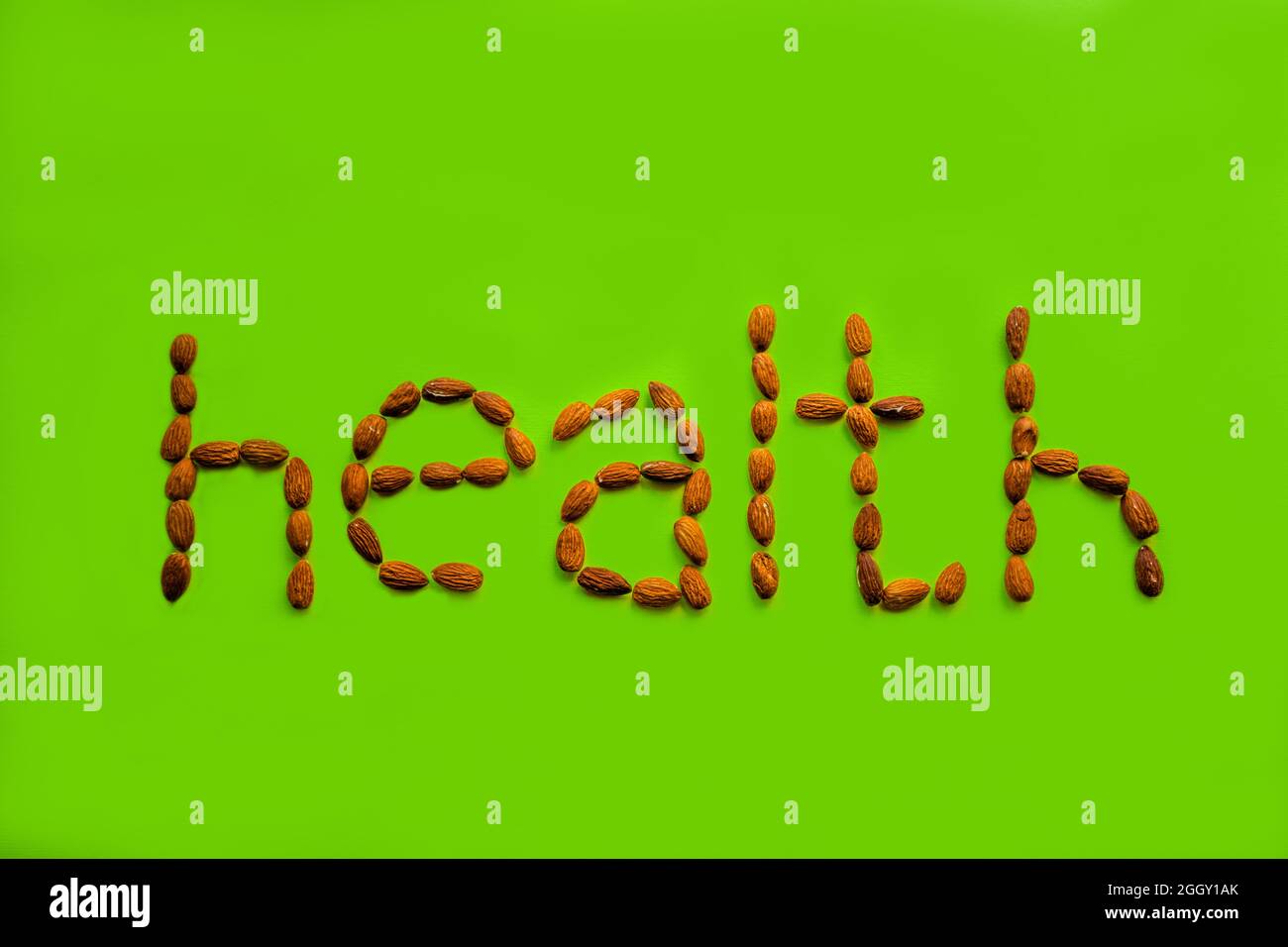 The word health laid out from almond nuts on a green background Stock ...